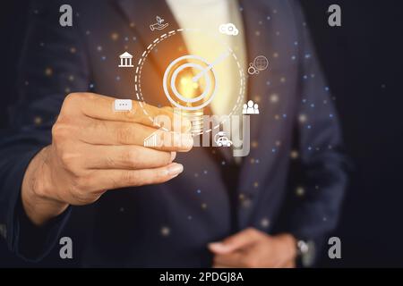 Businessman holding a light bulb with REVENUE inscription, new business ...