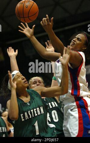 Eastern Michigan's Patrice McKinney, center, goes up against DePaul's ...