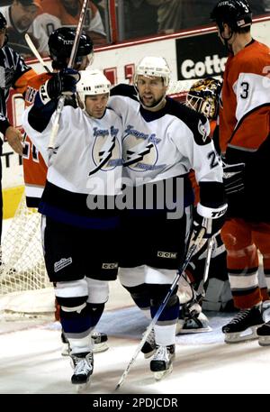 Philadelphia Flyers' Dmitry Afanasenkov, left, fends off an attempt by ...
