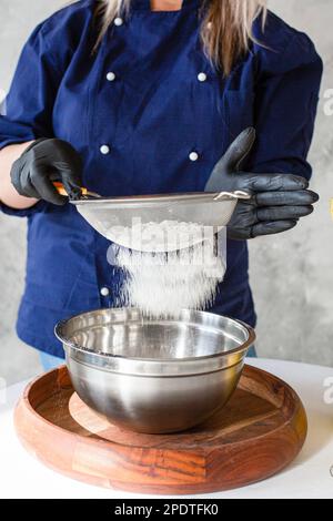 Woman sifting flour through old sieve on kitchen board Stock Photo - Alamy