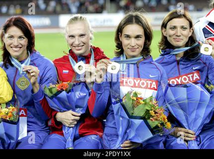Members of the Russian relay team pose with their national flag after ...