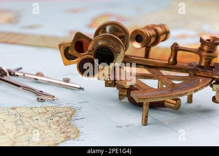 nautical sextant with optics, compass and ruler lying on paper world ...