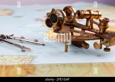 nautical sextant with optics, compass and ruler lying on paper world ...