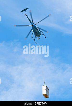 Bottom view of blue helicopter flying overhead Stock Photo - Alamy