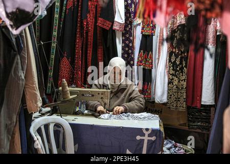 Farha Dana, seen in her small shop cutting material to sew in the Old ...