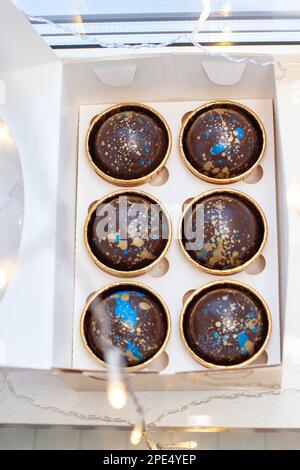 Chocolate spheres in golden gift box with burning candle Stock Photo ...