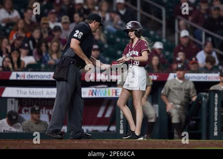 A member of the Texas A&M Aggies Diamond Darlings brings baseballs to ...