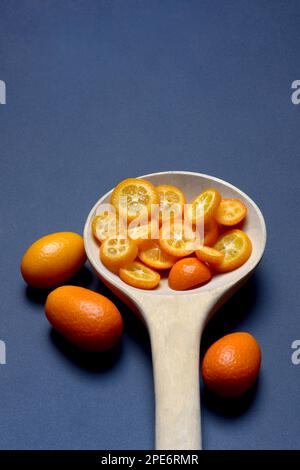 Kumquat (Fortunella) and kumquat slices in wooden ladle Stock Photo - Alamy