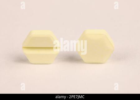 Hexagonal pills on light pink background. Extreme closeup. High ...