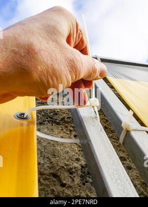 Fastening process of the outdoor vinyl advertising banner to the metal ...