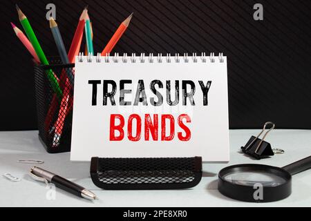TREASURY BONDS text on paper with magnifier, coffee and keyboard on ...