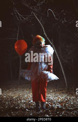 Terrifying clown with red air balloon on black background. Halloween ...