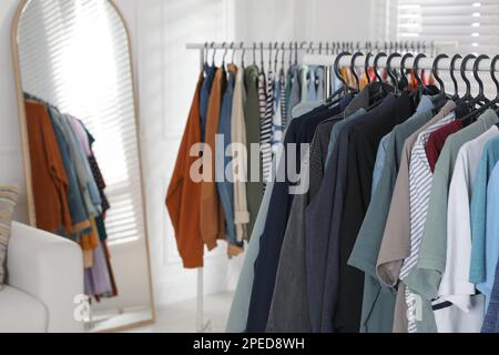 Racks with stylish clothes indoors. Fast fashion Stock Photo - Alamy