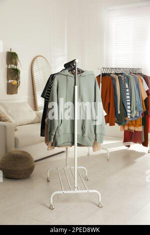 Racks with stylish clothes indoors. Fast fashion Stock Photo - Alamy