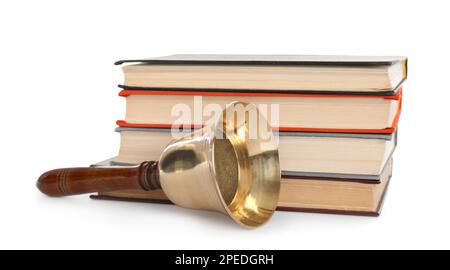 School bell with wooden handle and stack of books on white background ...