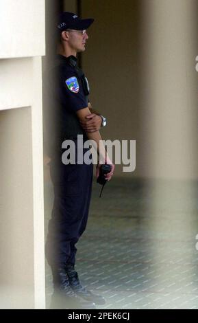 A Costa Rican police officer stands guard as the bodies of two children ...