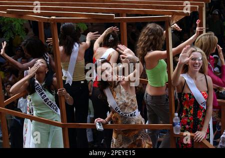 Candidates for the 2004 Miss Universe Pageant appear over a carriage ...