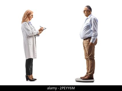 Male doctor checking weight of a mature man standing on a weight scale ...
