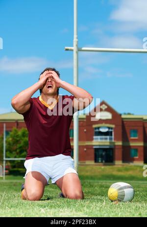 Its a mans sport. Full length shot of a young rugby kneeling on the ...
