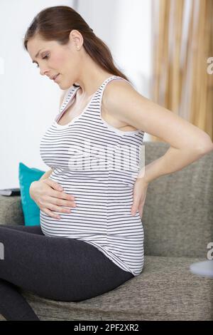 Young pregnancy woman having labor contractions pain touching her tummy ...