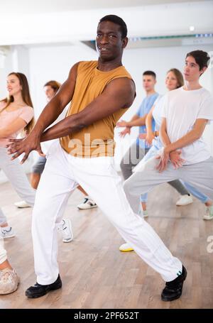 Group of different people rehearsing dance in dance studio Stock Photo ...