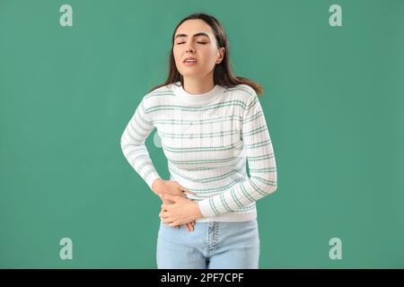 Young woman with appendicitis on green background Stock Photo - Alamy