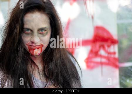 Sinister expression from an attractive zombie with blood around her ...