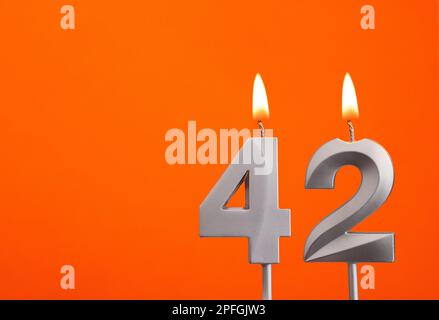 Candle number 42 - Birthday in blues foamy background Stock Photo - Alamy