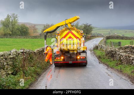 Cleaning out drains on a rural road to help prevent flooding on the ...
