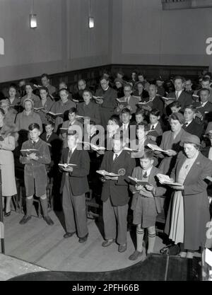 1940s, historical, well-dressed adults wearing coats, standing with ...
