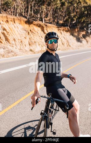 Male cyclist relaxing after an intense ride. Profesional rider resting ...