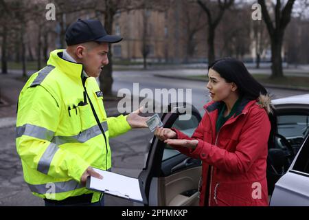 Woman giving bribe to police officer out of car window Stock Photo - Alamy