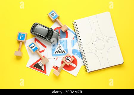 Many different road signs, notebook with sketch of roundabout and toy ...