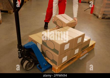 Worker sorting cardboard boxes in warehouse, closeup. Logistics concept ...