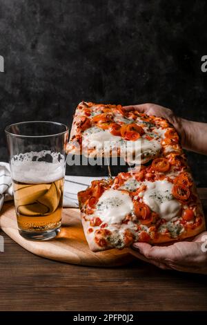 Two hands hold a fresh red tomato and a yellow bell pepper. The setting ...
