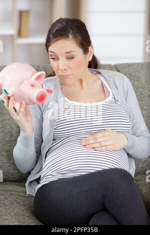pregnant woman or mom holding a piggy bank Stock Photo - Alamy