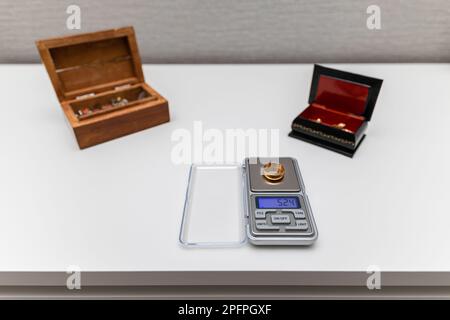 scales for small items are on the table. jewelry scale. golden ring ...
