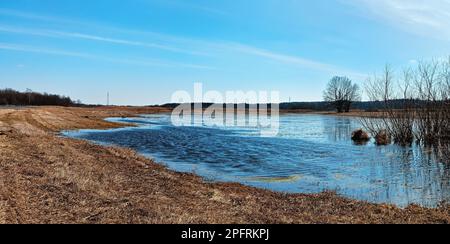Early spring, river flood on agricultural meadows. Reflection in ...