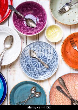 Different plates with bowls and spoon on blue background Stock Photo ...