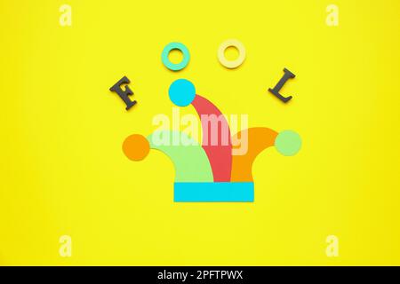 Paper hat and word FOOL on yellow background with space for text Stock ...