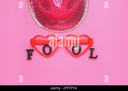 Word FOOL with eyeglasses and party hat on pink background Stock Photo ...