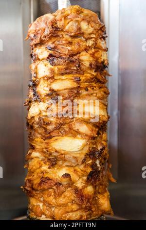 Juicy Greek traditional gyros grilled on fire and chopped by a knife ...