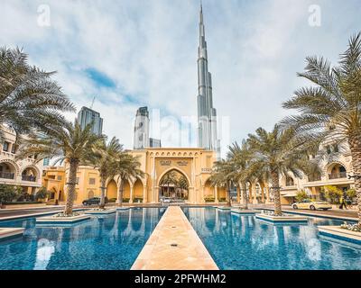 Dubai Downtown. square place with palm trees and pond with burj khalifa ...