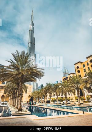 Dubai Downtown. square place with palm trees and pond with burj khalifa ...