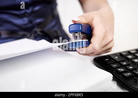 Office worker staples documents at office desk Stock Photo - Alamy