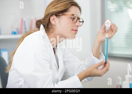 woman researcher using pipette to transfer resuspension of cells line ...