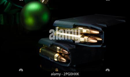Two loaded magazines with a Christmas ornament behind Stock Photo - Alamy