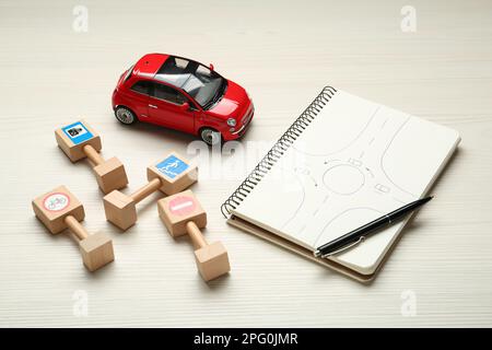 Different road signs, notebook with sketch of roundabout and toy car on ...