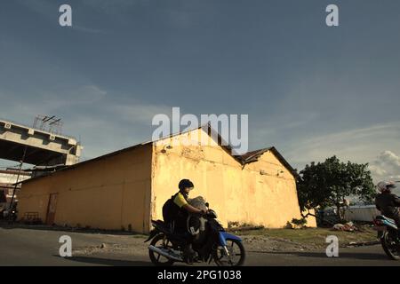 Motorists are photographed in a background of a warehouse building, in ...