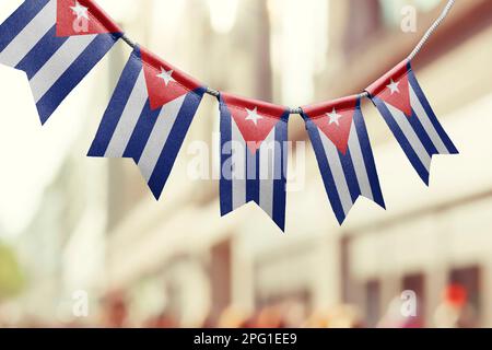 A garland of Cuba national flags on an abstract blurred background ...